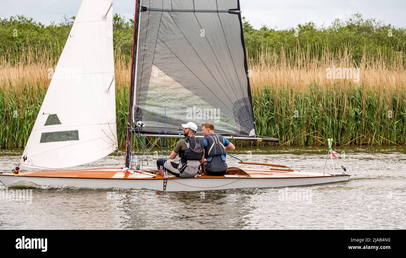 Horning, Norfolk, UK – May 28 2022. Two males on a traditional wooden ...