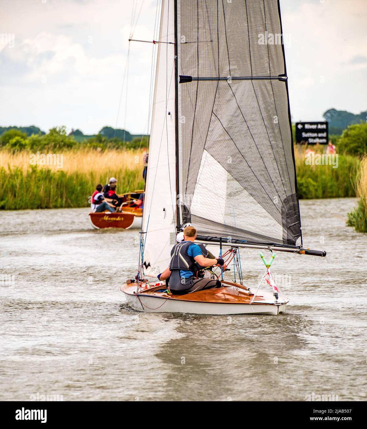 Horning, Norfolk, UK – May 28 2022. Two males on a traditional wooden ...