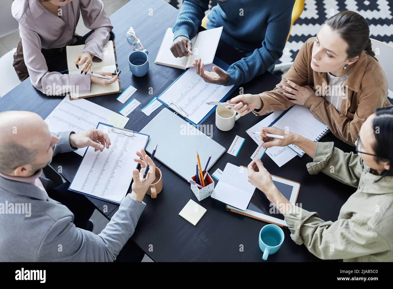 Top view at diverse group of people at meeting table in office setting ...