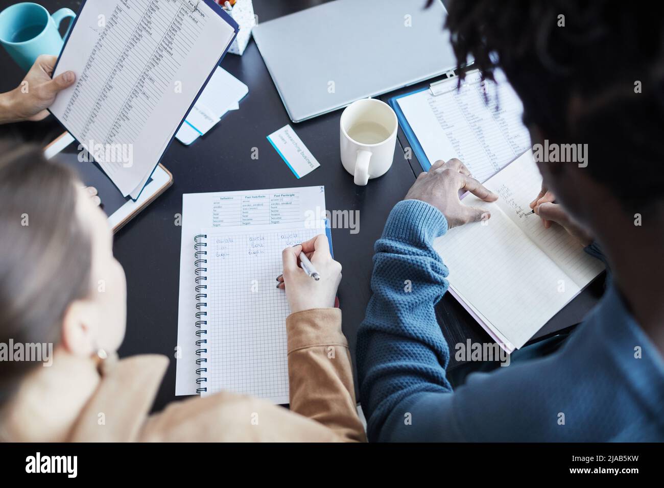 Top view at young black man taking notes during English seminar in ...
