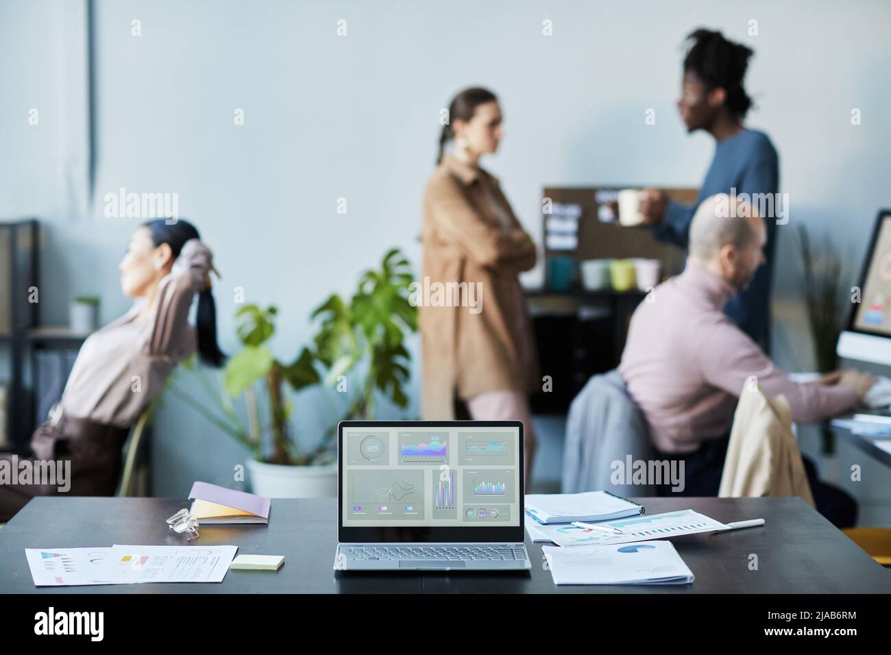 Background image of digital data charts on laptop screen in office with ...