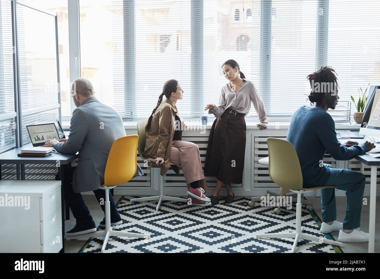 Balanced wide angle view at diverse group of people operating in ...