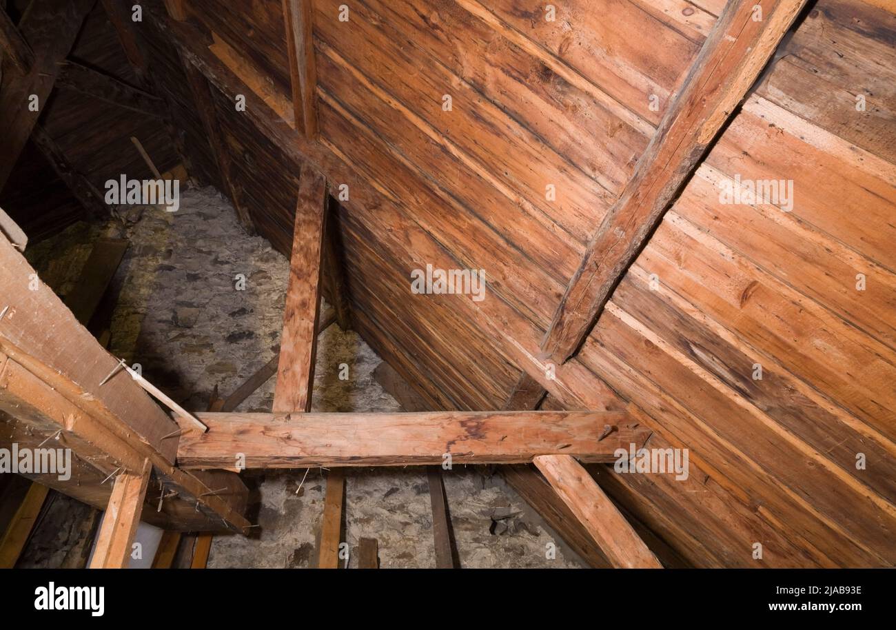 Exposed wooden beams, rafters and roof boards in attic of old circa ...