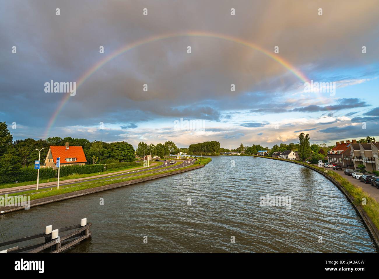 Bright colorful rainbow over channelized river Gouwe near the town of ...