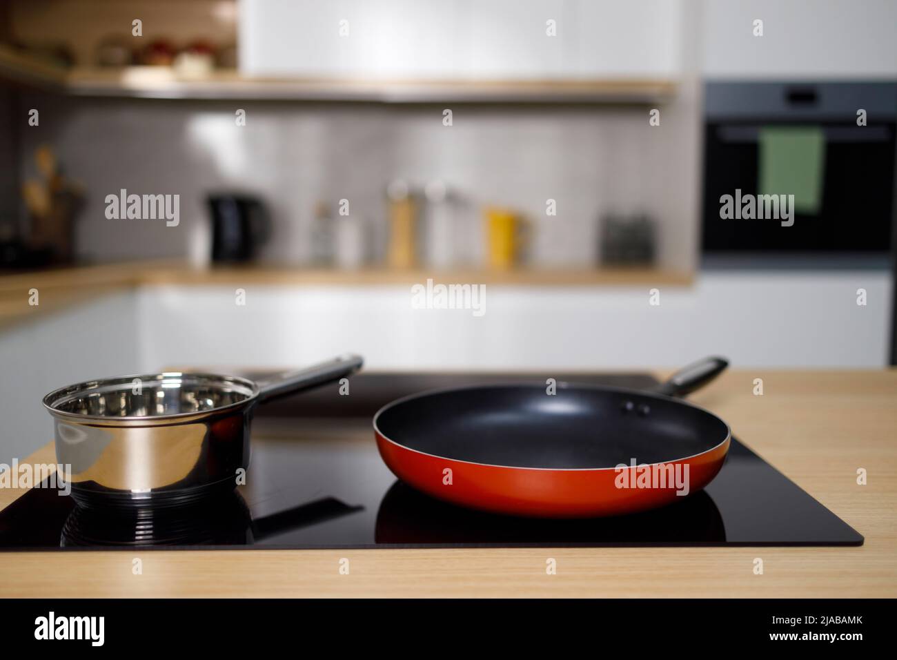 Frying pan and sauce pan on modern induction cooktop Stock Photo - Alamy