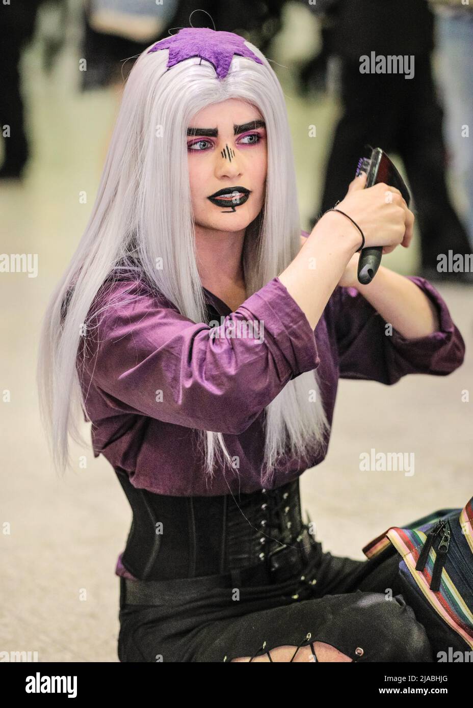 London, UK. 29th May, 2022. A cosplayer tends to her long haired wig ...