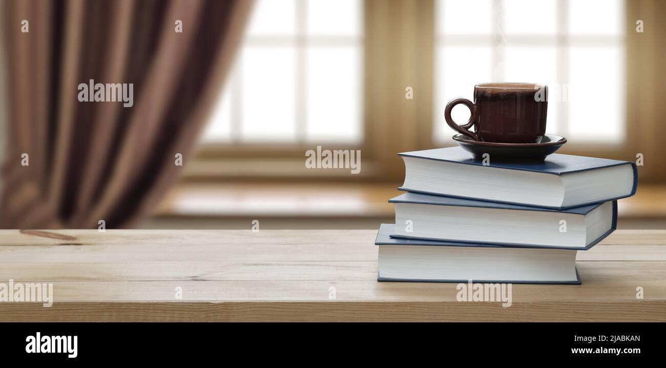 stack book and cup of coffee on wooden table. Light background Stock ...