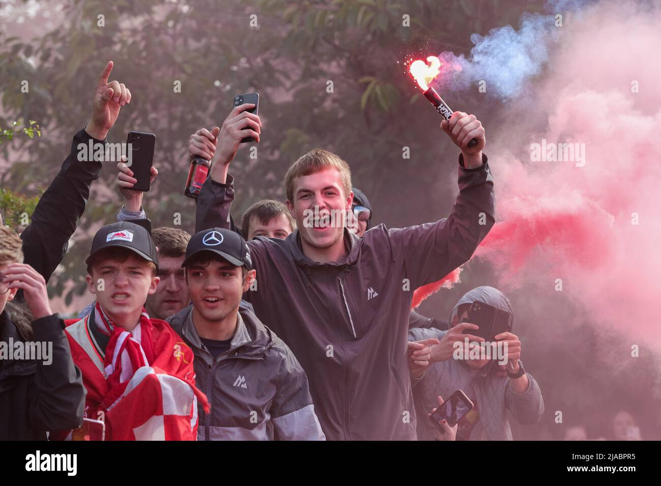 Supporters hold up flares and cheer as the Liverpool FC squad celebrate ...