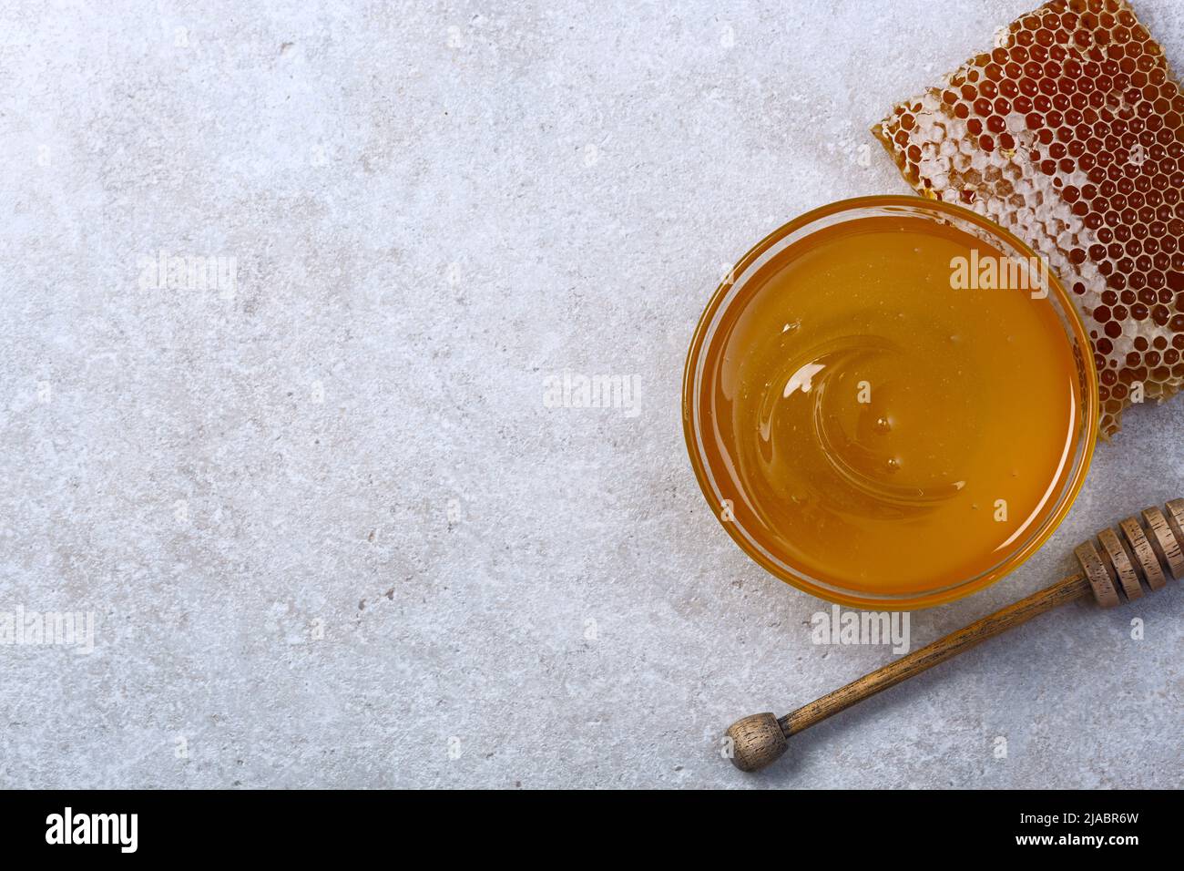 Honey background. Sweet honey in the comb, glass jar and a spoon for ...