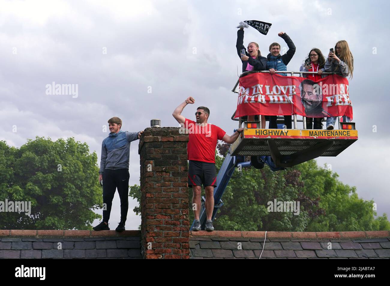 Liverpool fans watch the team-bus pass by during the trophy parade in ...