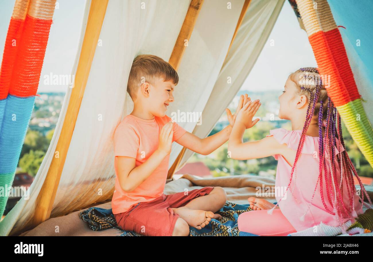 Brother and sister playing together. Happy kids family playing in tent ...