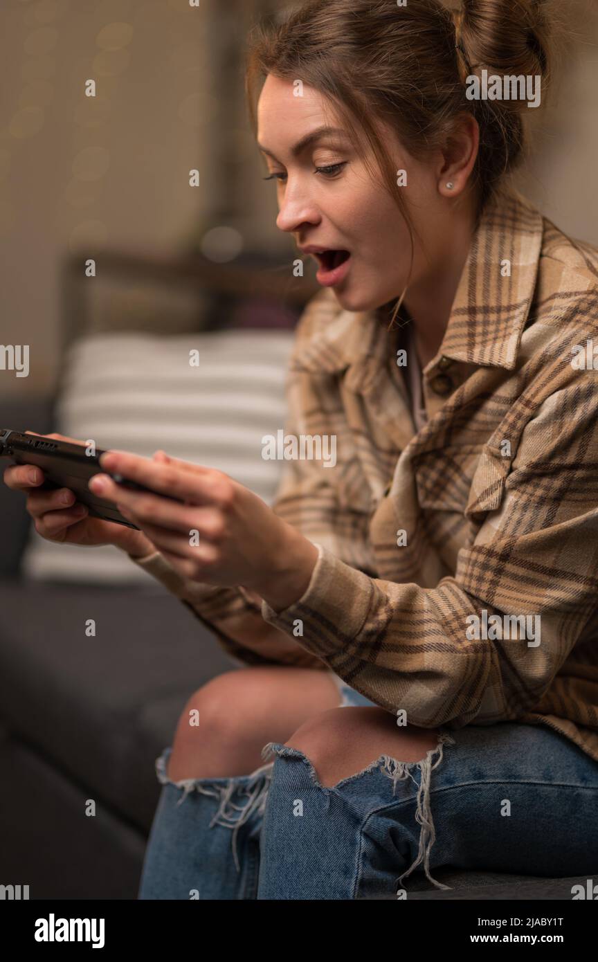 Close-up. Girl gamer plays on a portable game console in video games ...