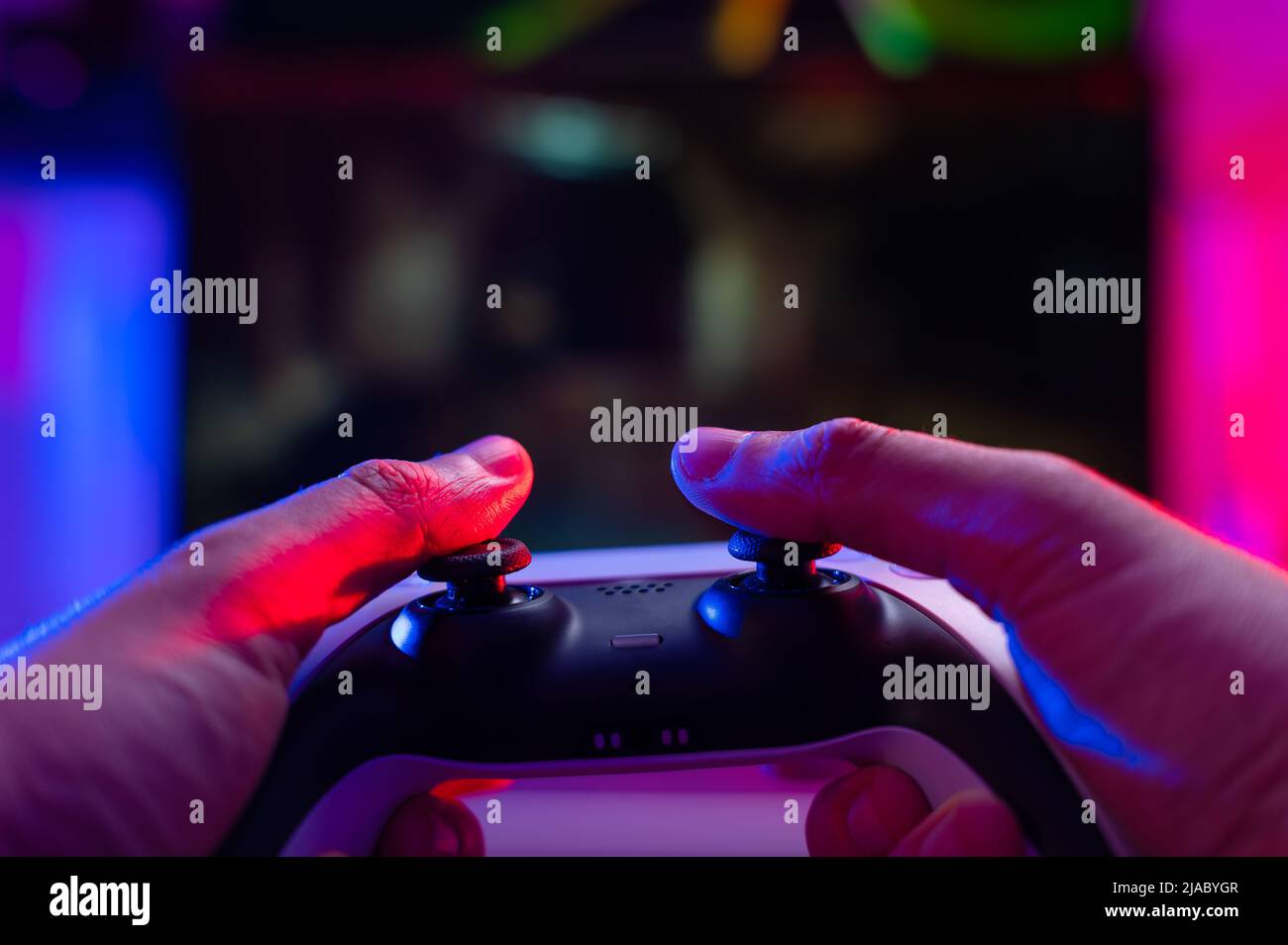 Close-up. Joystick in the hands of a gamer on a dark background. Neon ...