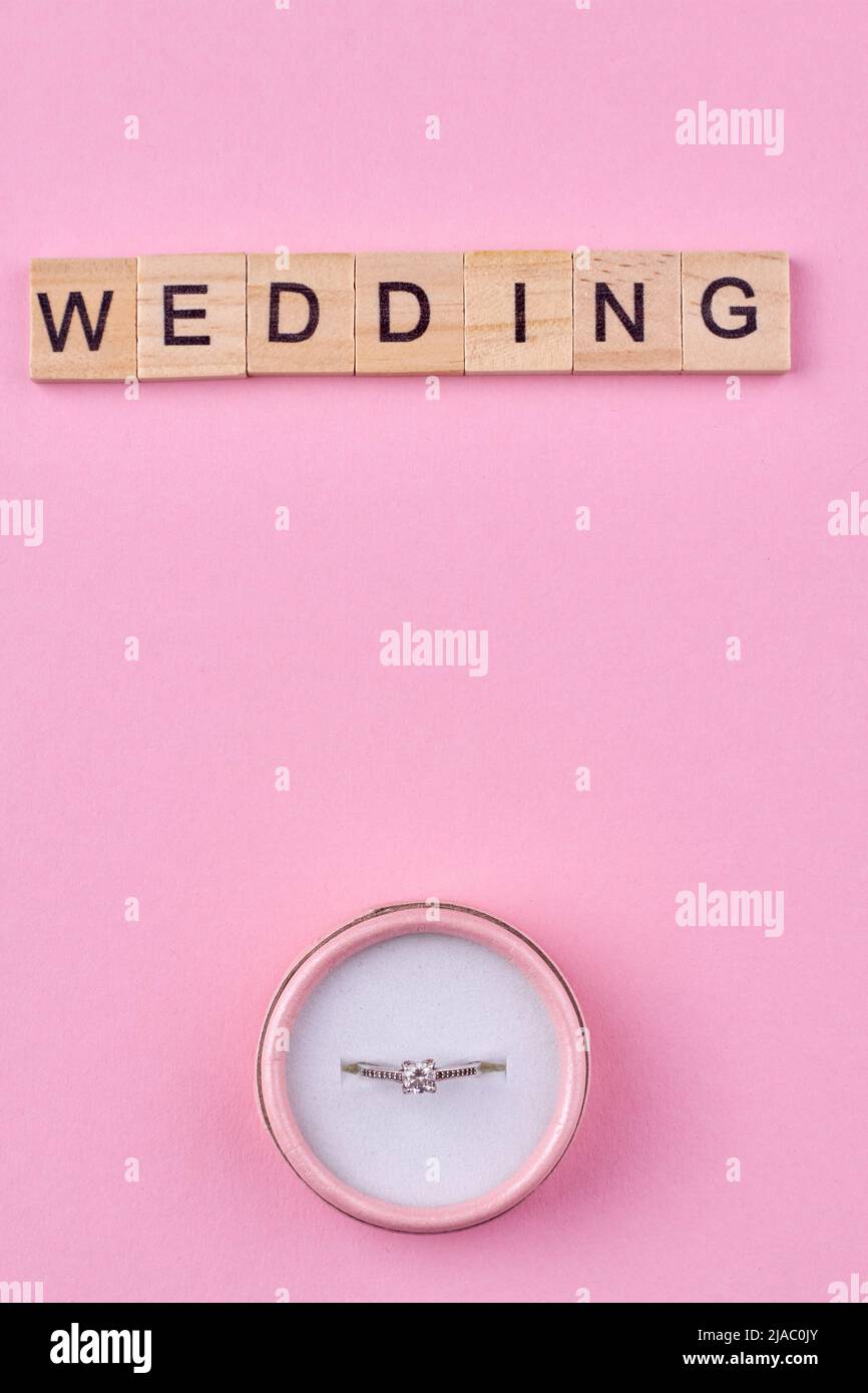 Top view of wooden blocks with word WEDDING and engagement ring in box ...