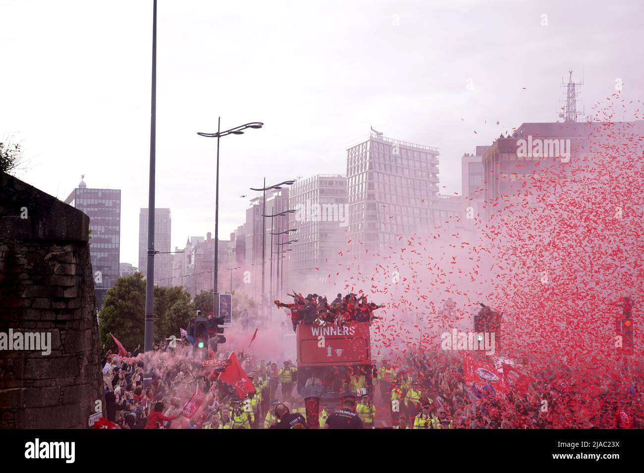 Confetti explodes as Liverpool players ride on an open-top bus during ...