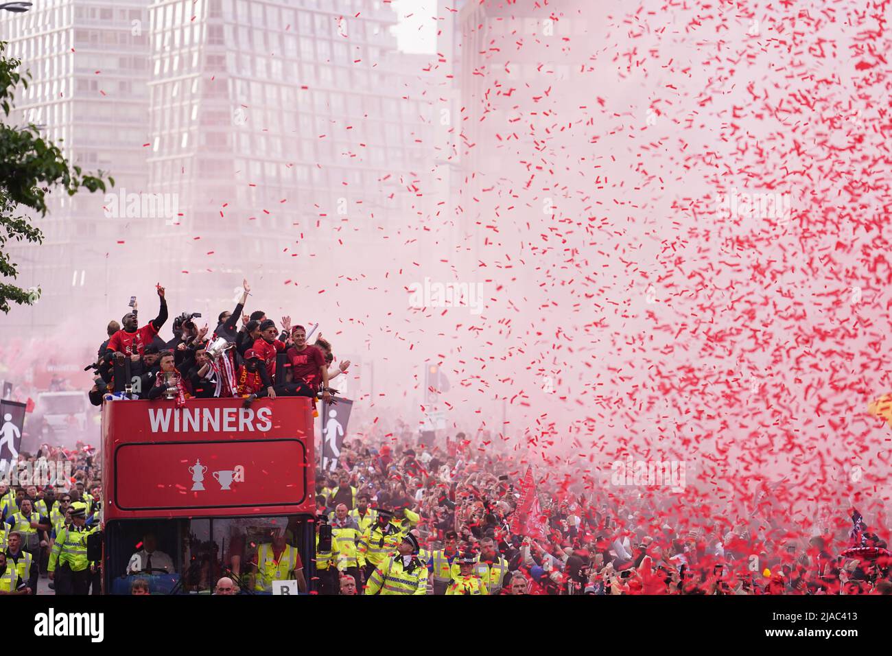 Confetti explodes as Liverpool players ride on an open-top bus during ...