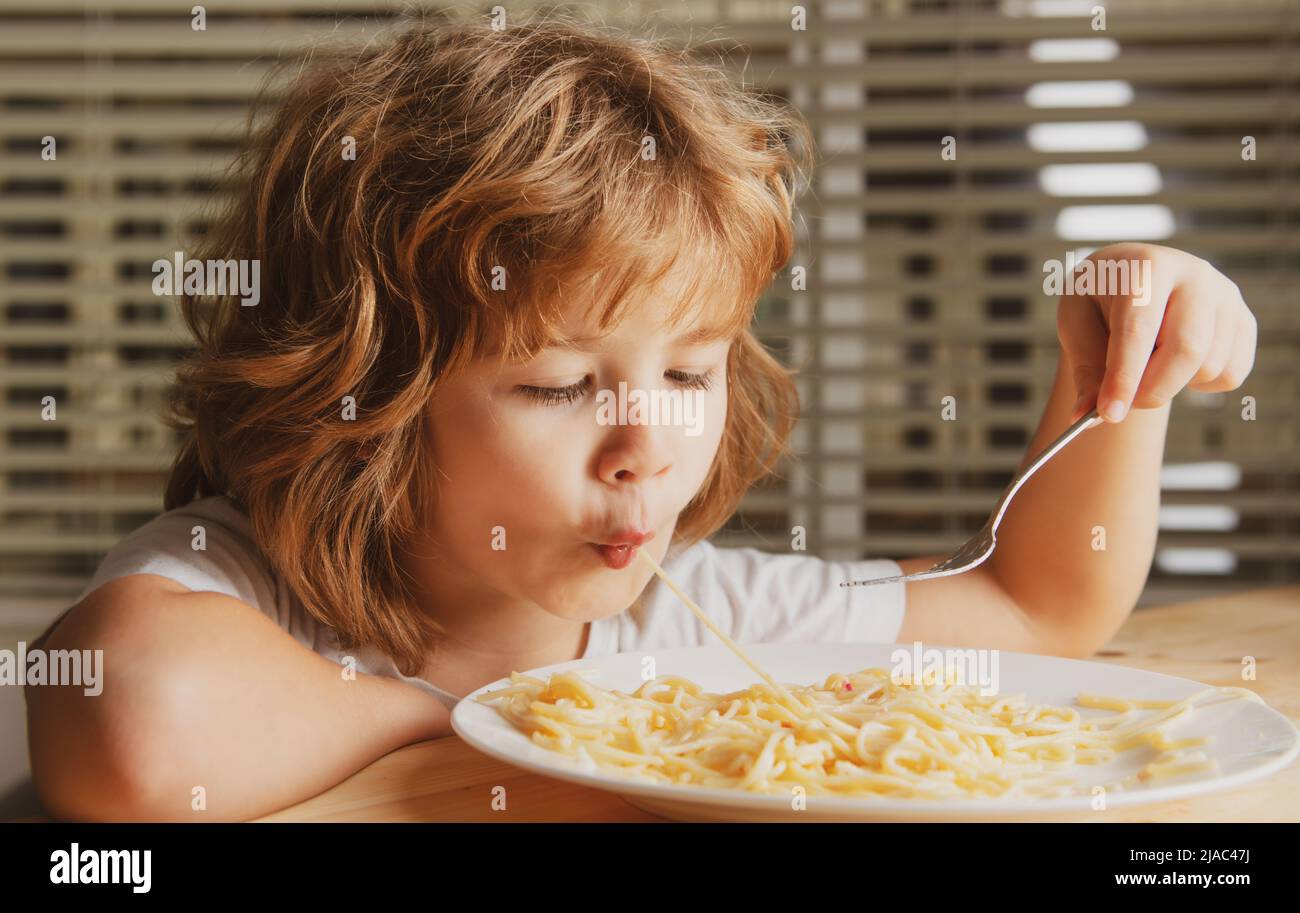Close up head shot of child eating pasta, spaghetti. Kids face, little ...