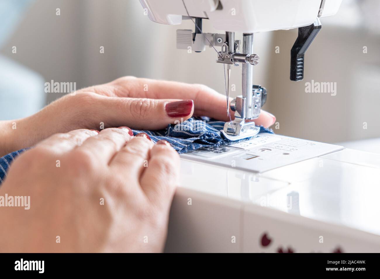 woman hands close up sewing on machine stitching fabric material Stock ...