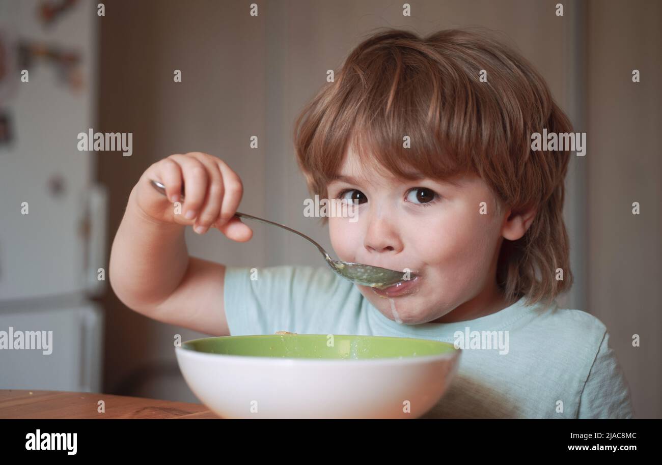 Cute child eating breakfast at home. Parenthood. Baby eating. Young kid ...