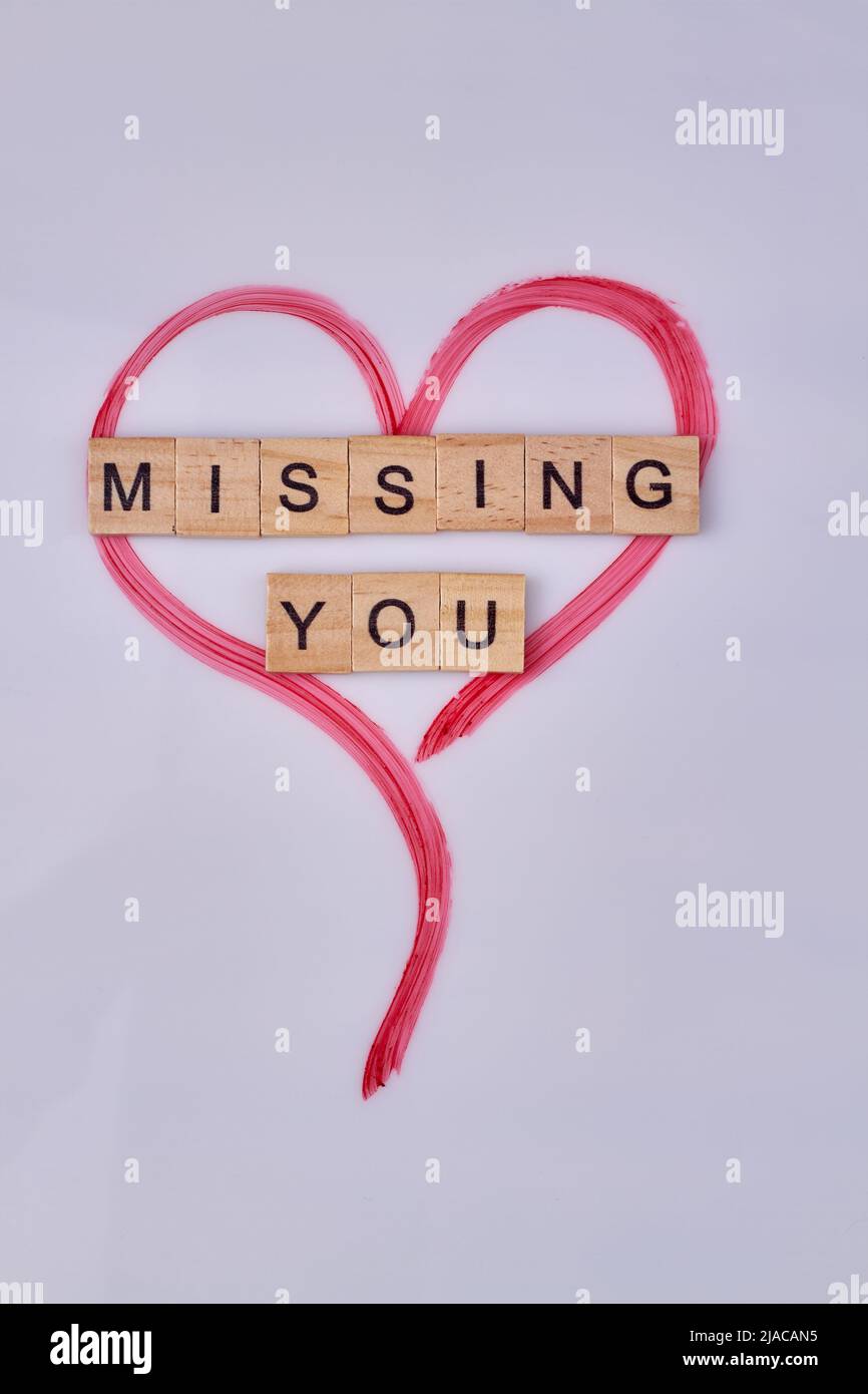 Hand drawn heart and missing you text on wooden cubes. Vertical shot ...