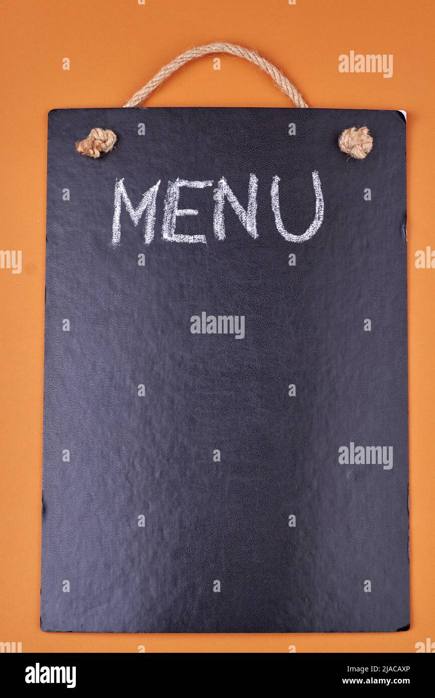 Word MENU written with chalk on black board on color background. Top ...