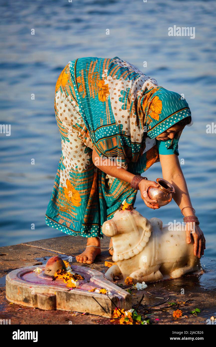 Indian woman performs morning pooja on holy river Narmada ghats Stock ...
