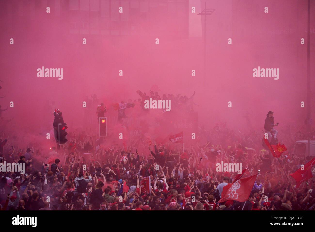 Liverpool players pass fans in their open-top bus during the trophy ...