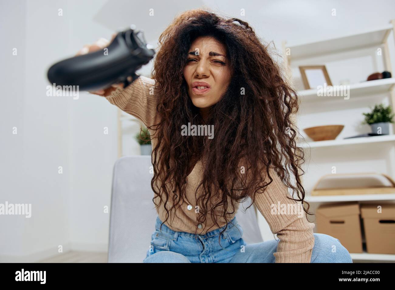 Irritated angry pretty tanned curly Latin lady lose game throw joystick ...