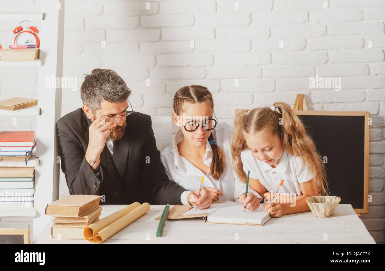 Elementary students with teacher in classroom. Father teaching ...