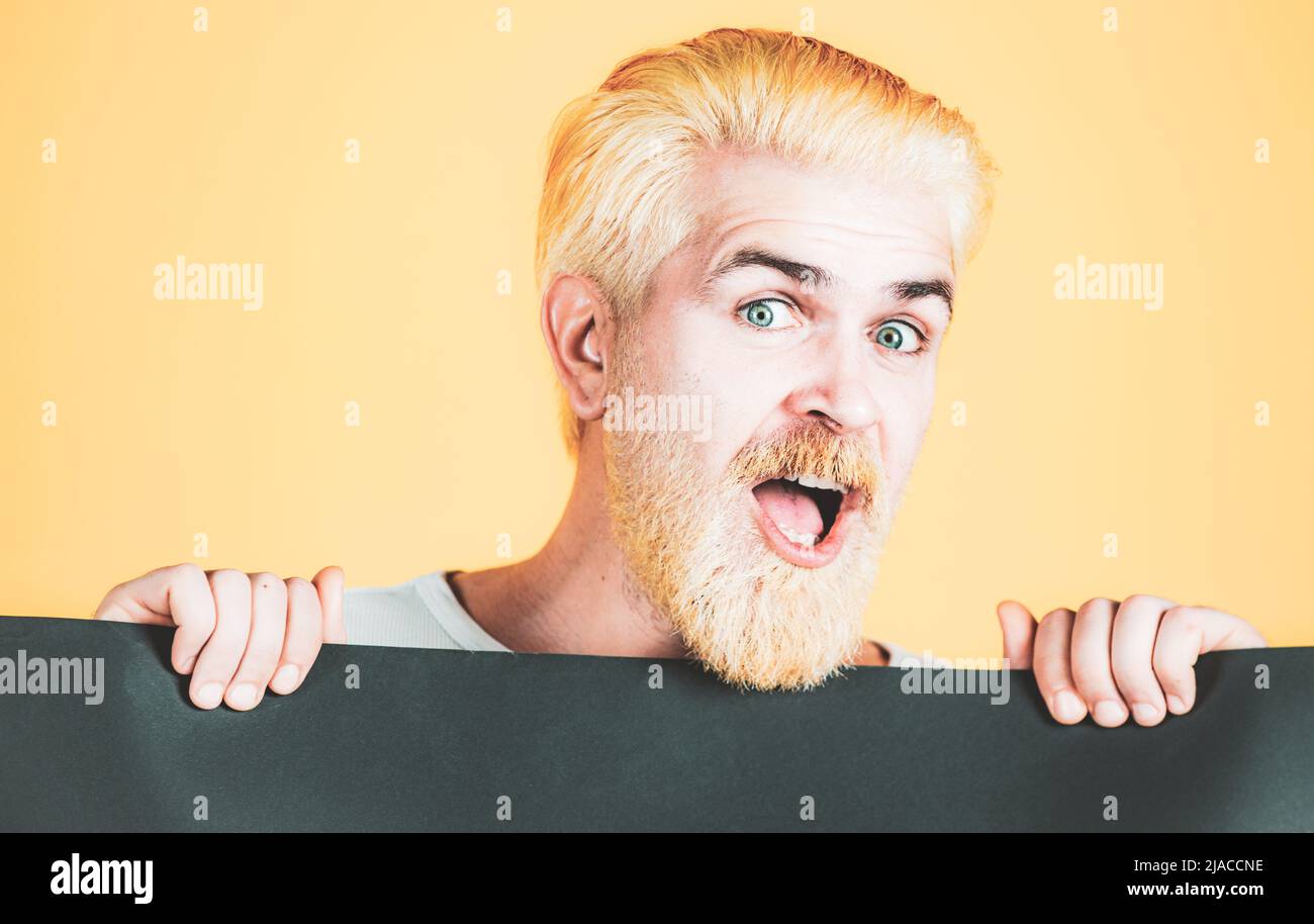 Excited man holding a blank billboard isolated on background. Copyspace ...