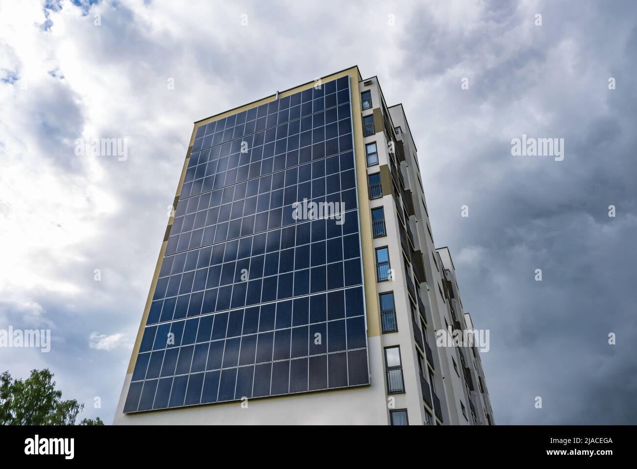 solar panels on the wall of a multi-storey building on storm clouds ...