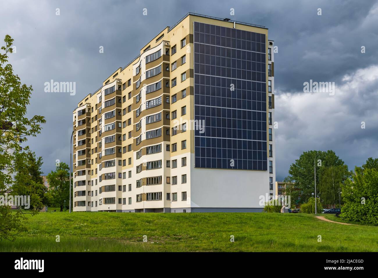 solar panels on the wall of a multi-storey building on storm clouds ...