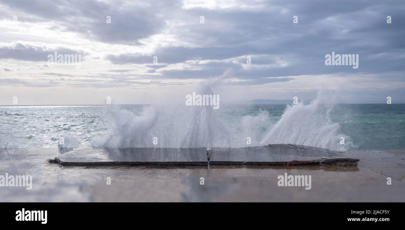 Wave breaking on broken quay concept. Breakwater breakage at pier in ...