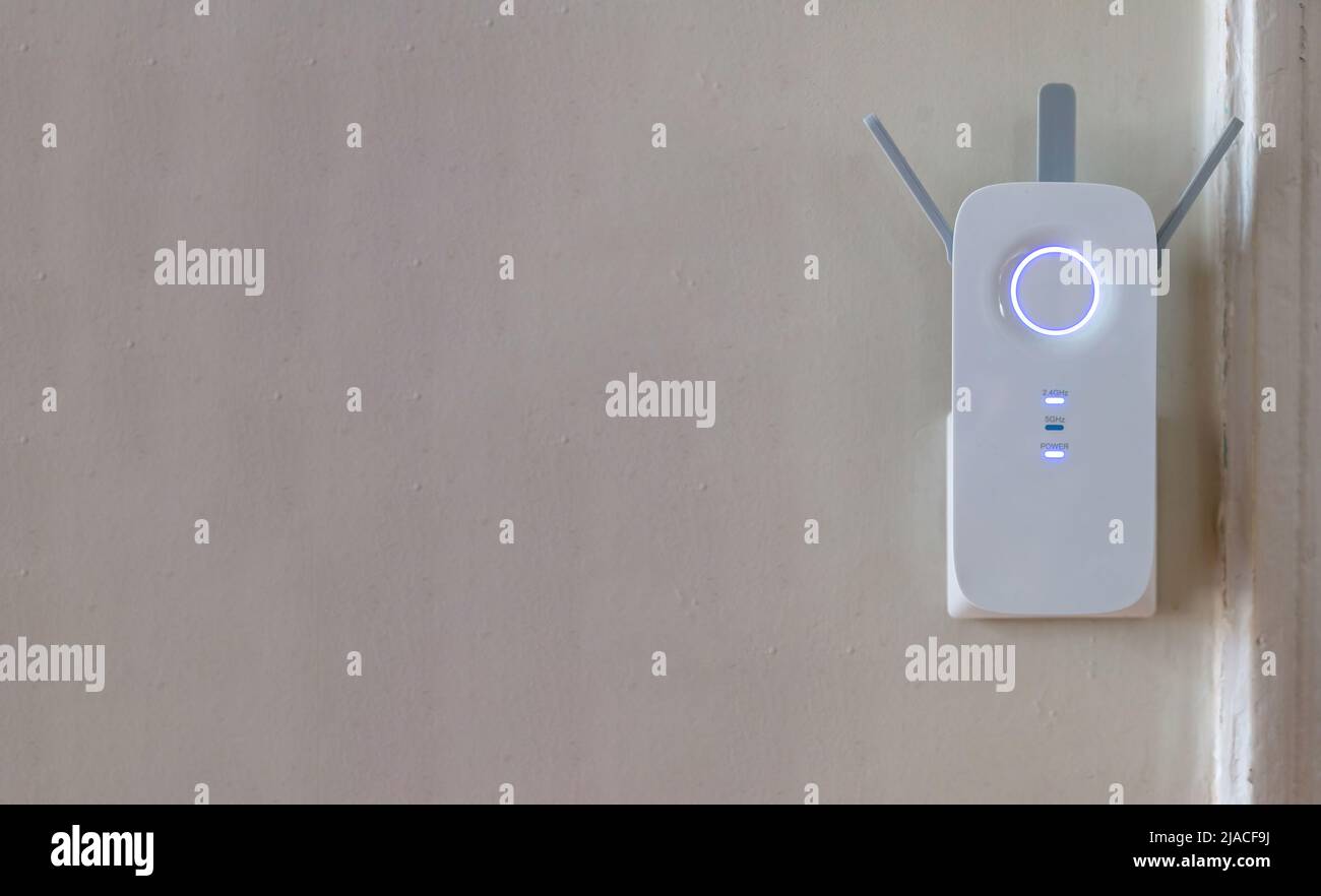 Wifi Extender at power outlet on grey empty wall background. Wireless ...