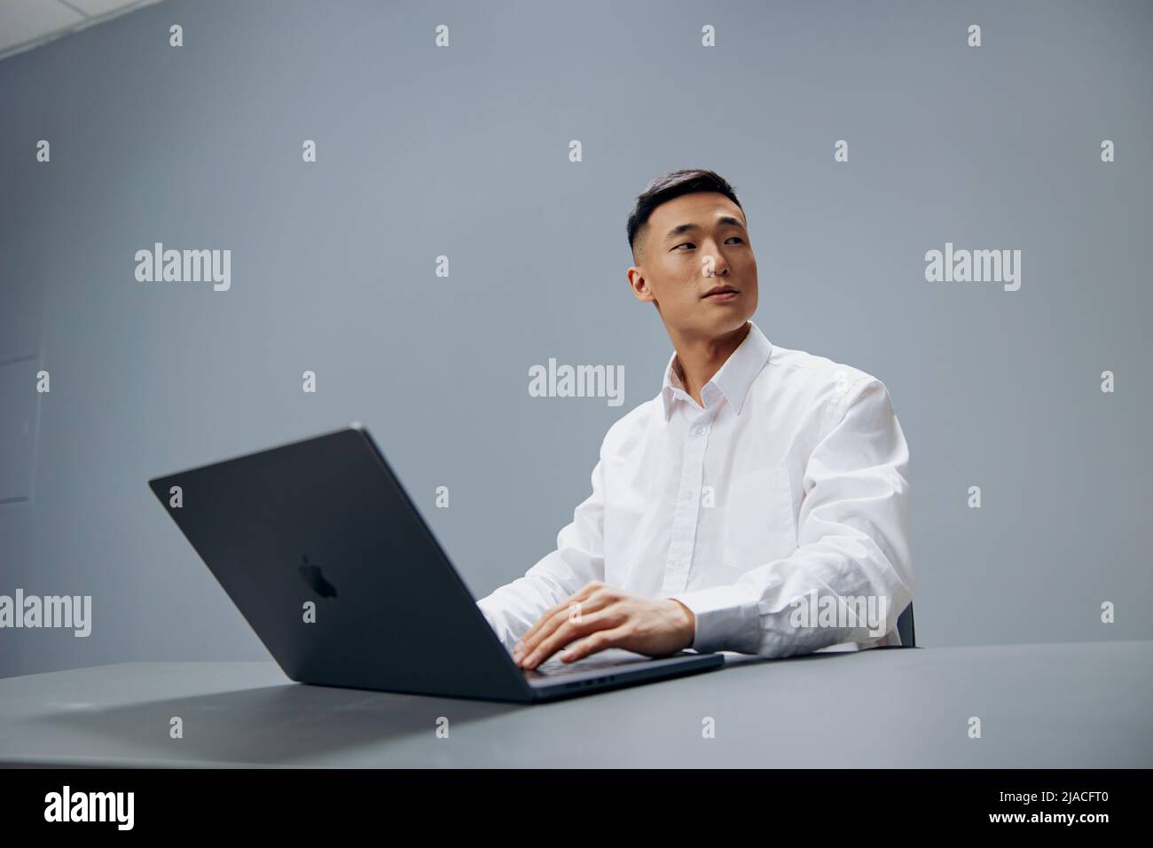 businessmen working on a laptop sitting at a table in the office Gray ...