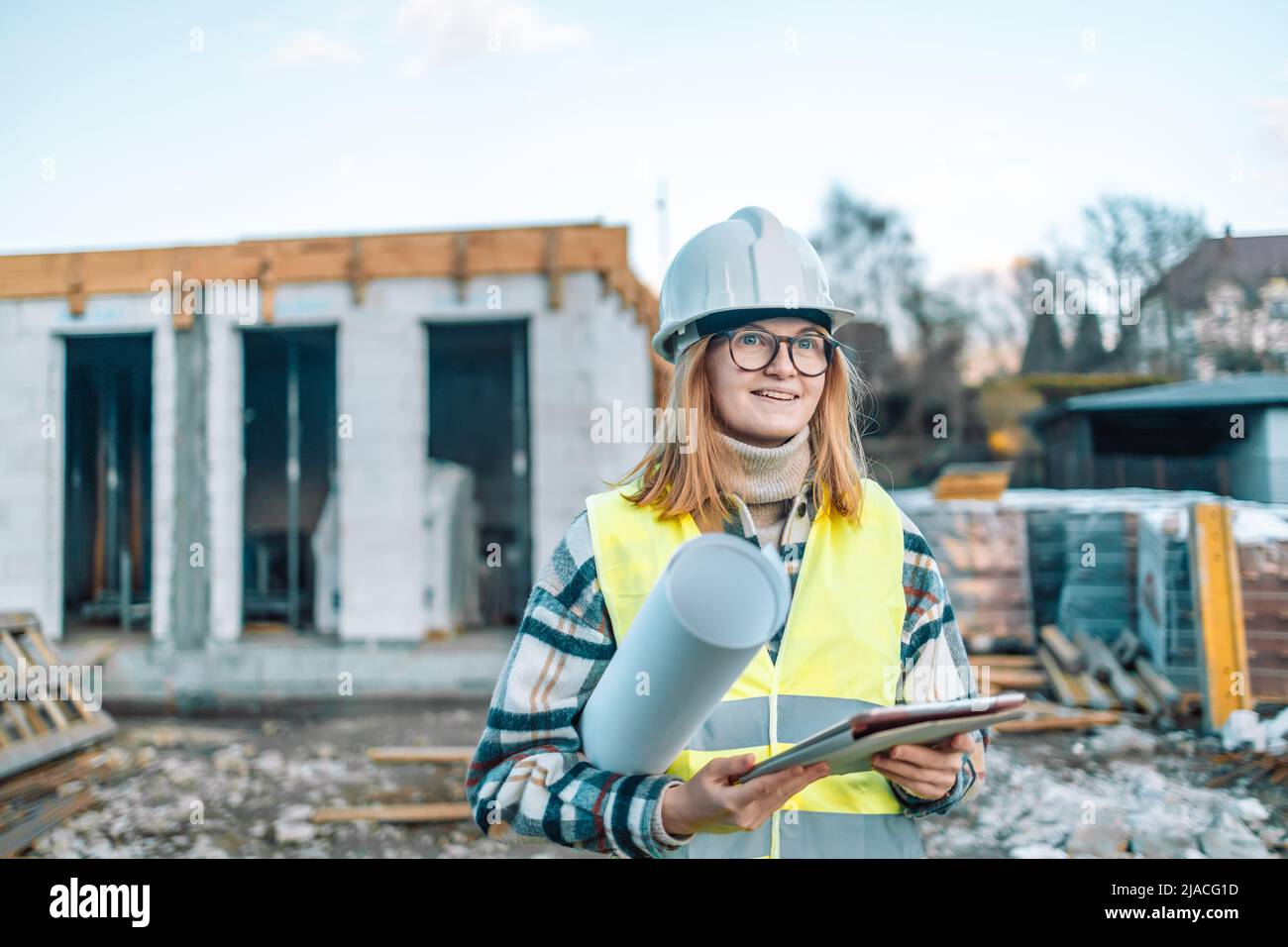 young engineer girl in a protective uniform at a construction site ...