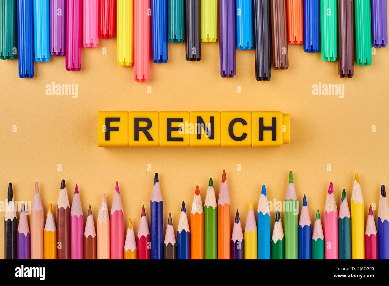 Frame from colorful pencils and word FRENCH written on plastic cubes ...