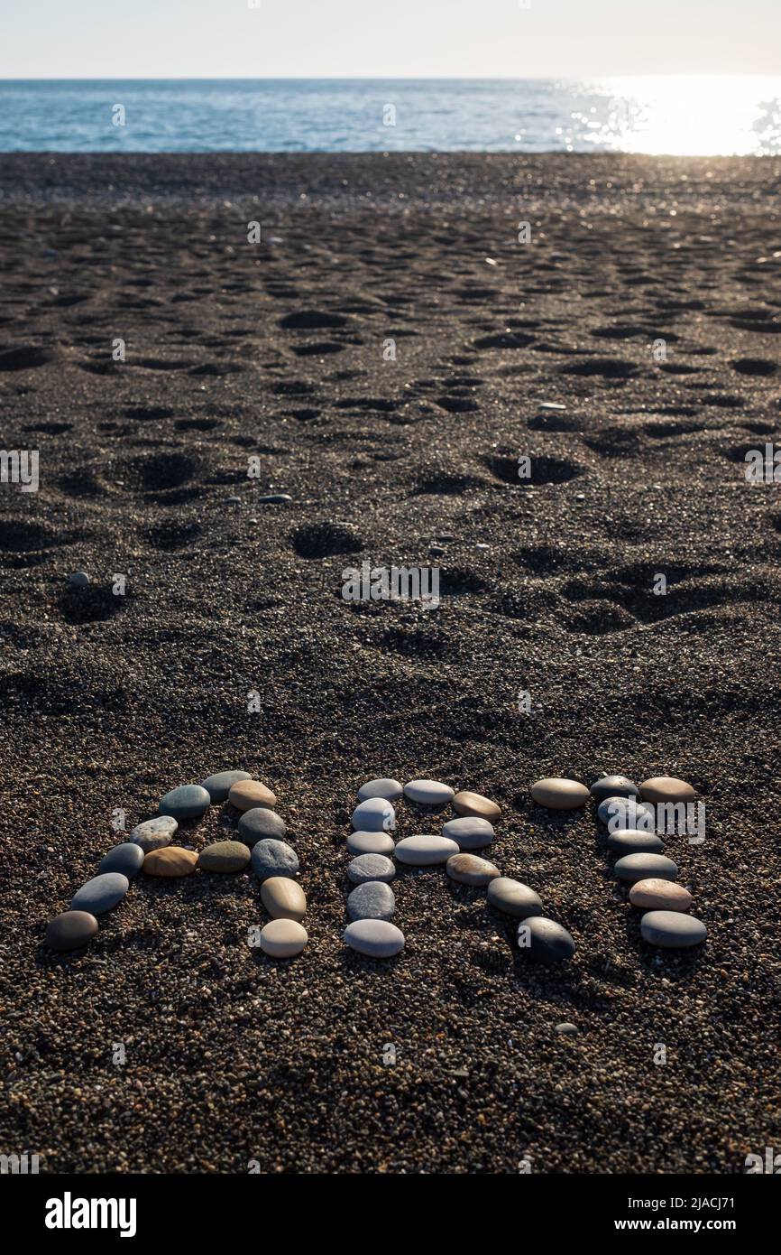 Word art made from stones on sandy beach during sunset Stock Photo - Alamy