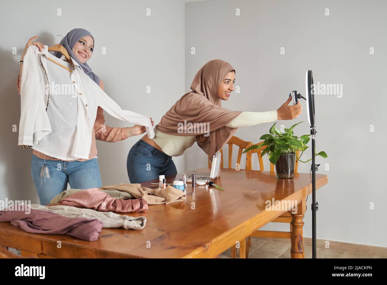 Two muslim vloggers setting up camera to record make-up and clothing ...