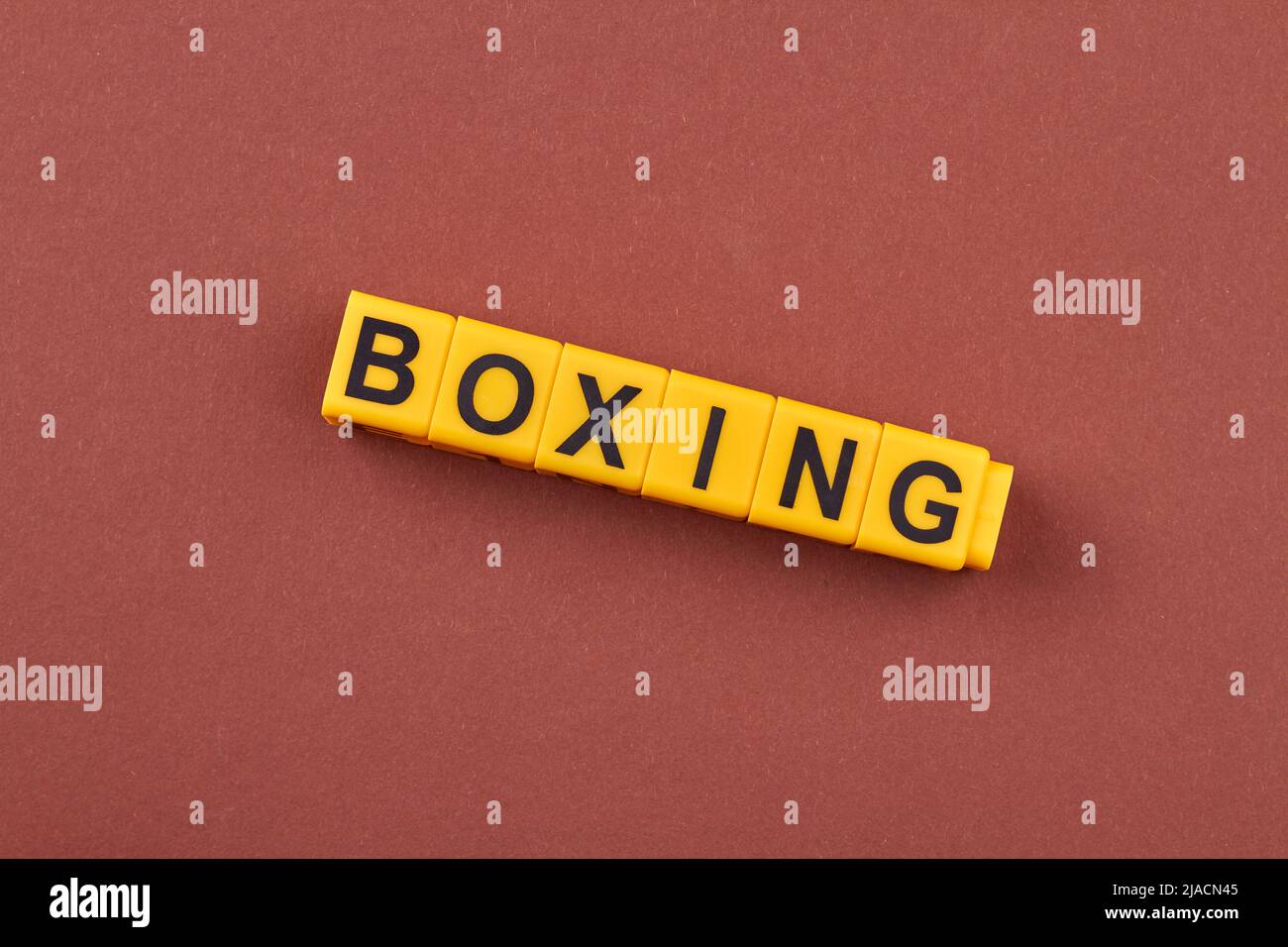 The word boxing written on yellow cubes against brown background. Sport ...
