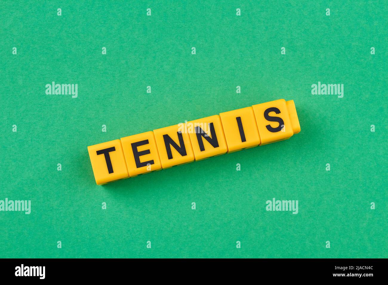 Word tennis written on yellow cubes against green background. Sport ...