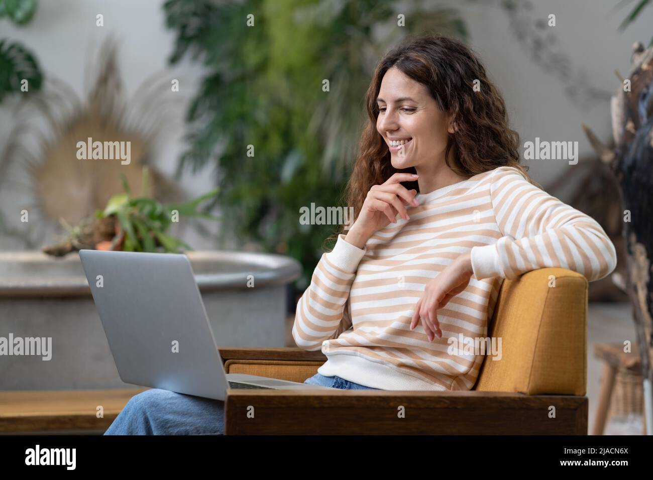 Italian woman waving hello, having video call on laptop sitting in ...
