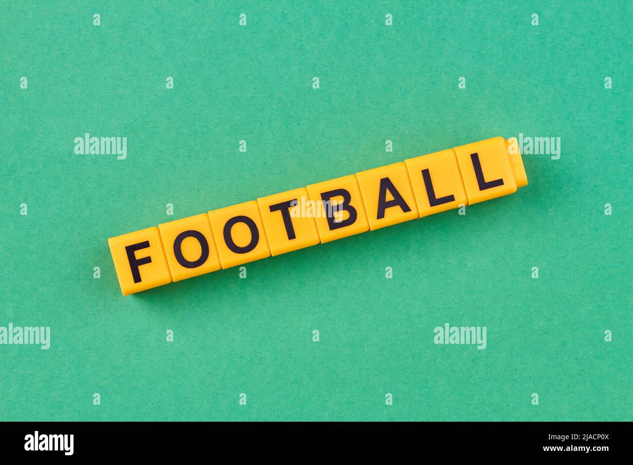 Yellow cubes with inscription football on green background. Space for ...
