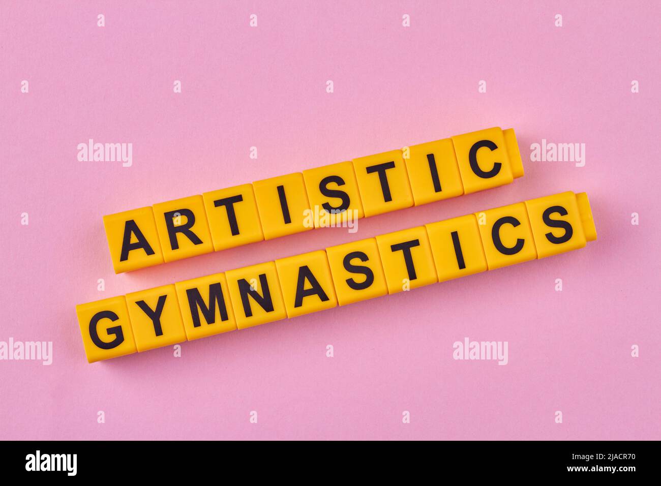 The inscription artistic gymnastics written on yellow cubes against ...