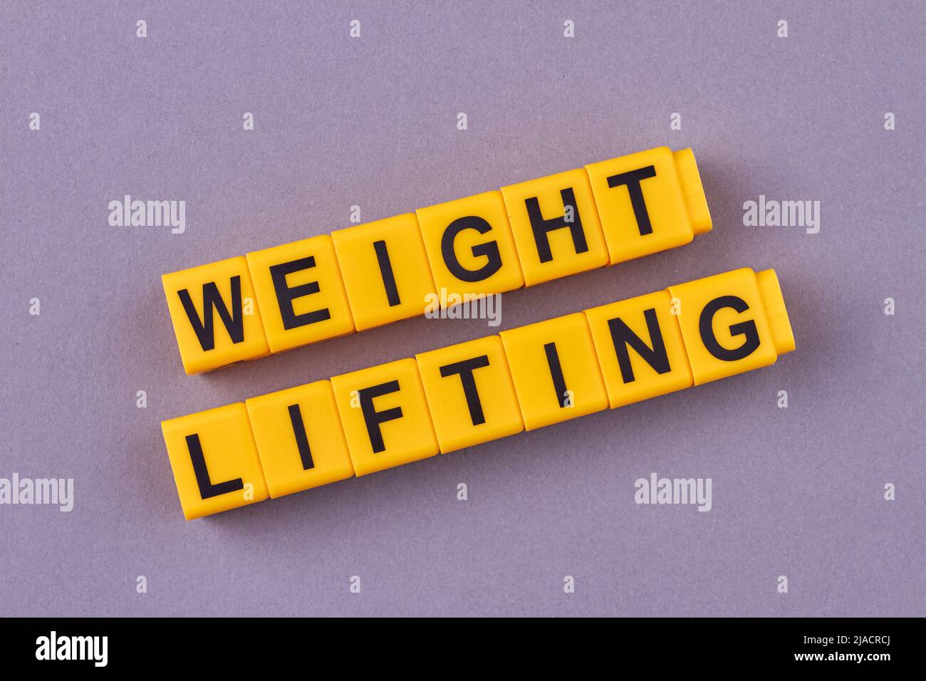 The inscription weight lifting written on yellow cubes against purple ...