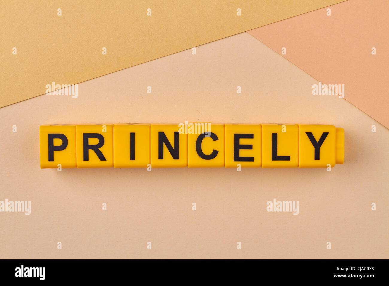 The word princely written on yellow cubes on color background close up ...