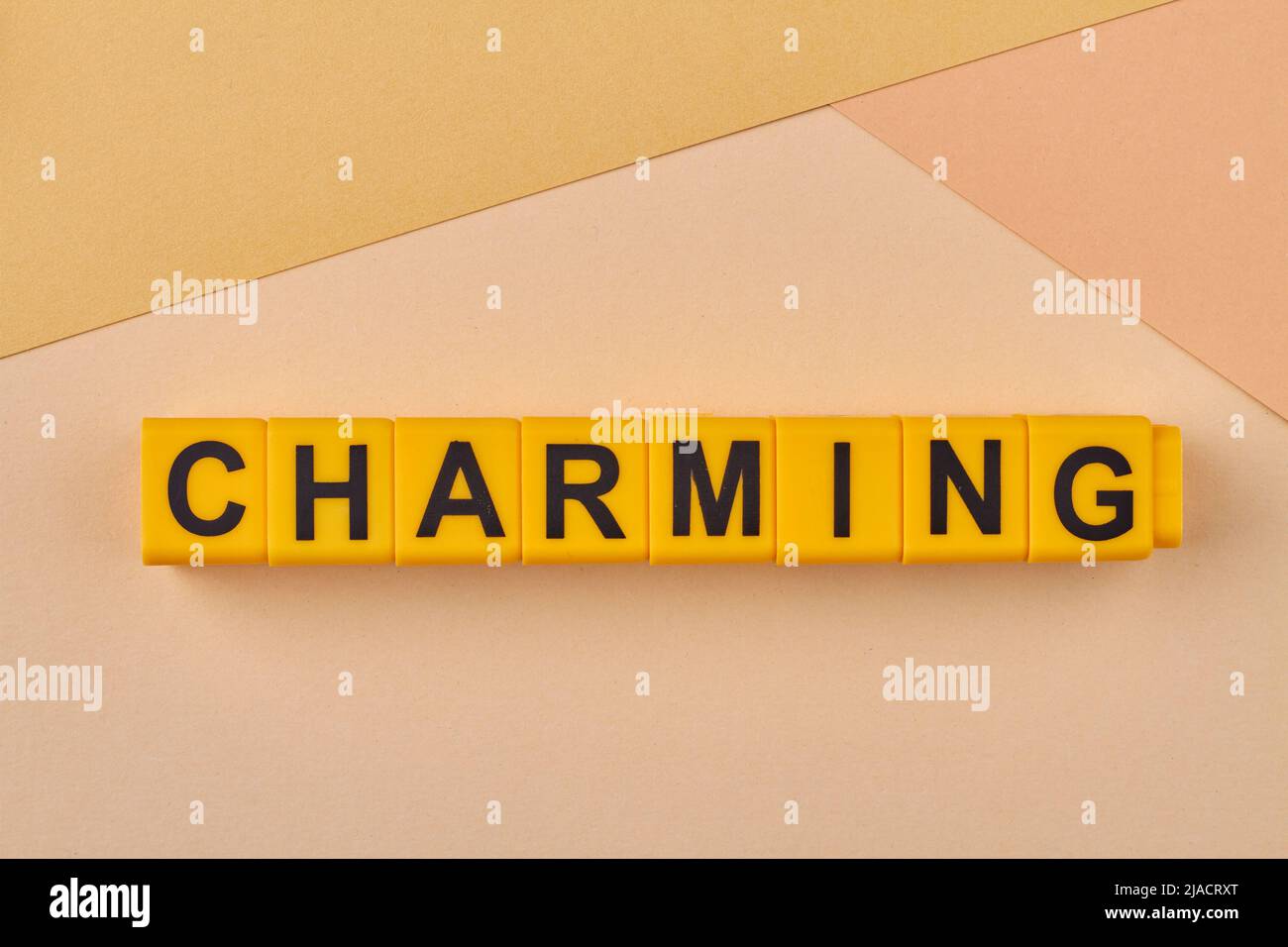 Charming word written on alphabet blocks on light background close up ...