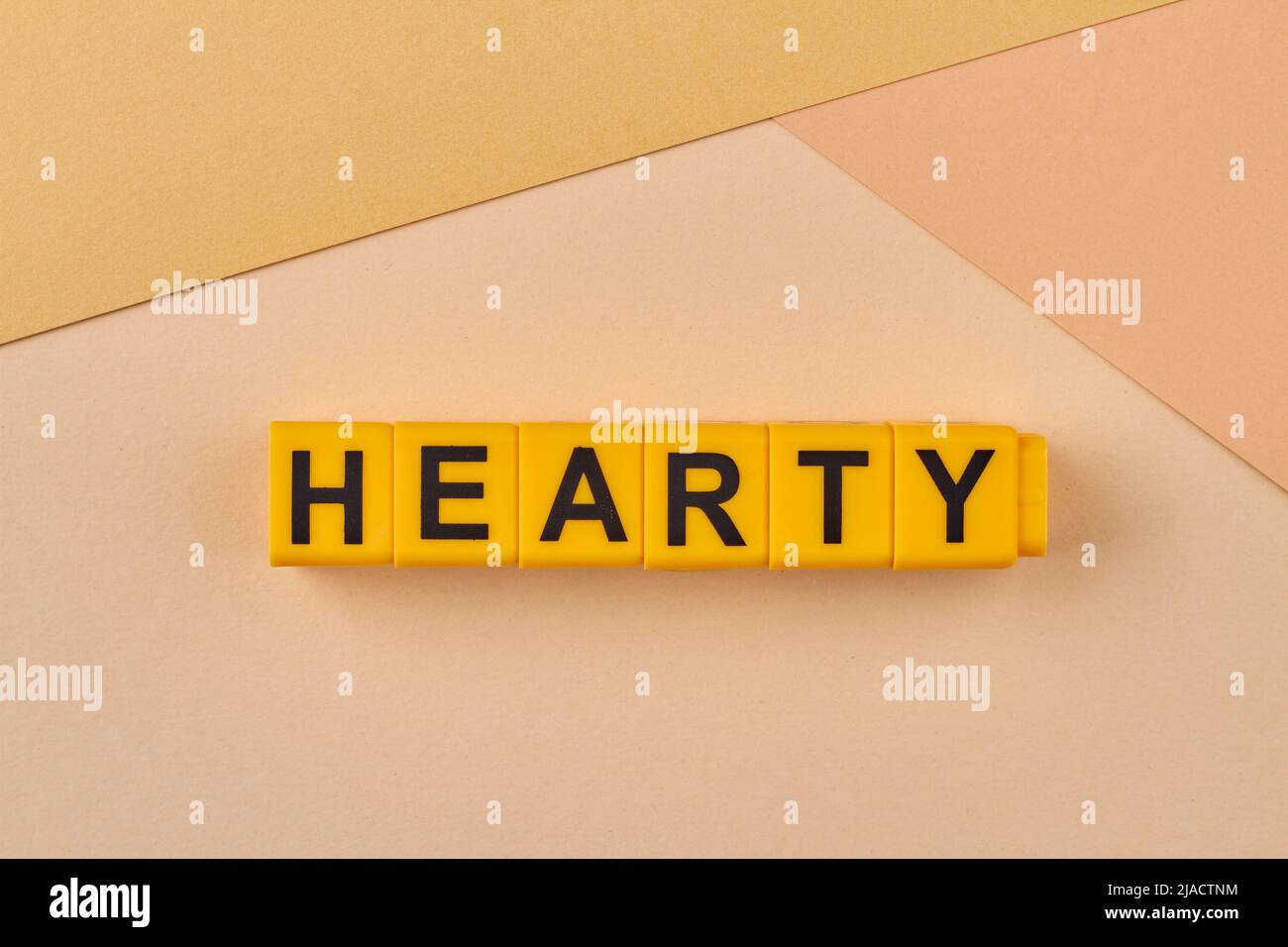 Word hearty written on yellow blocks against color background ...