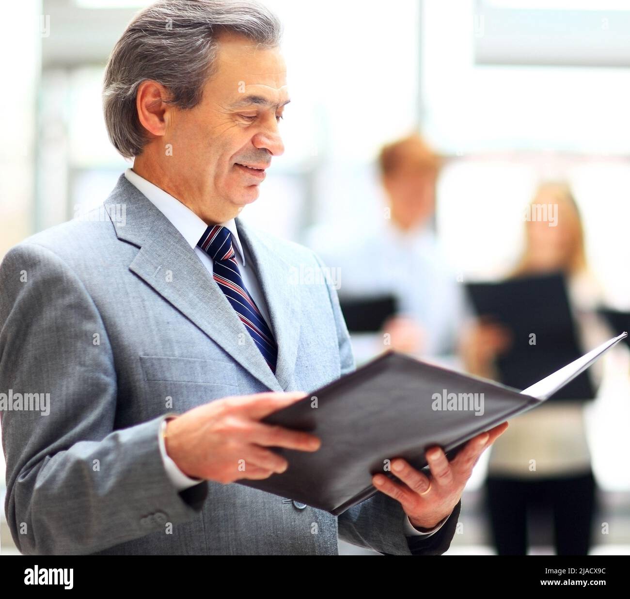 Happy smart business man with team mates discussing in the background ...