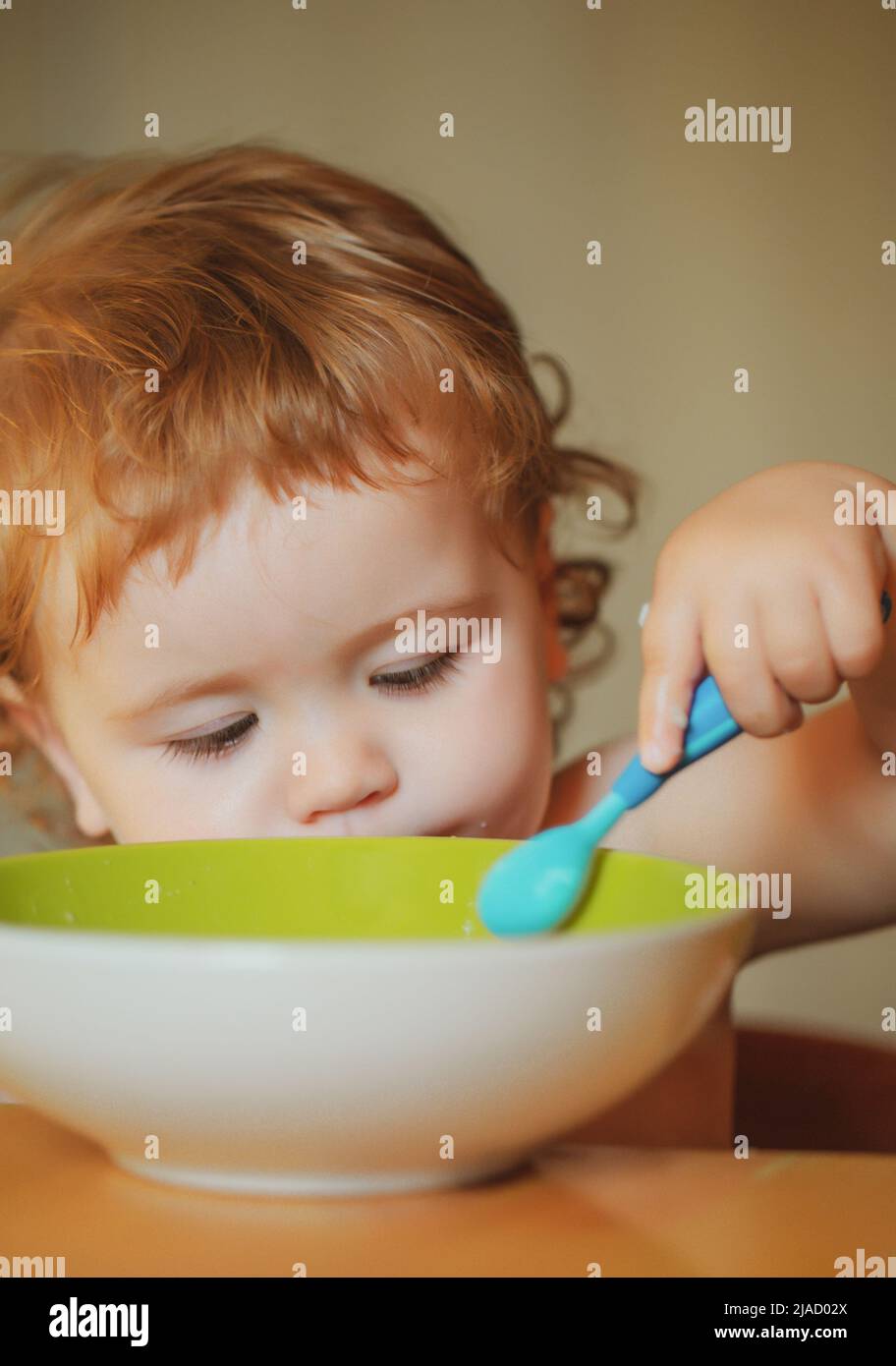 Kid baby eat soup in the kitchen with dishes and spoon Stock Photo - Alamy